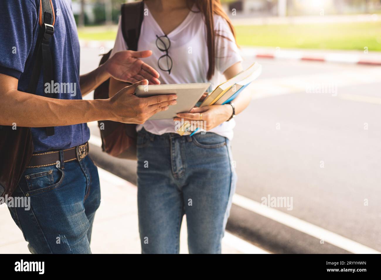 Close up of two college student discussion with tablet. Girl holding ...
