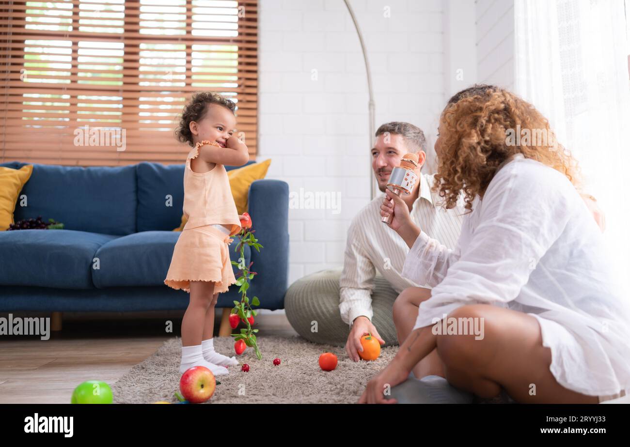 A little girl is having fun with her toys, and her mother is begging ...