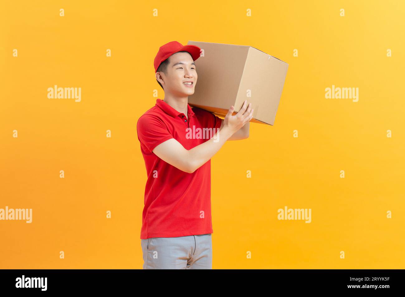 Asian delivery man in red uniform with parcel cardboard box isolated on ...