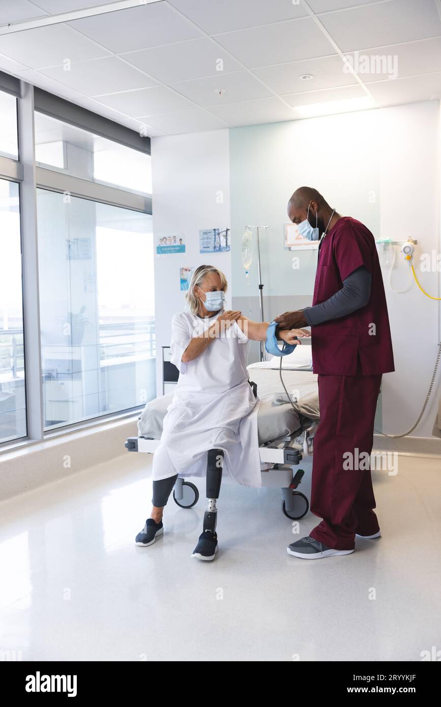 African american doctor measuring blood pressure of senior caucasian ...