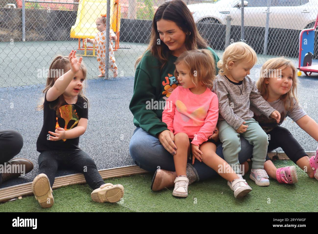 Staffer Mackenzie Hunt smiles as a child raises her hand to answer a ...