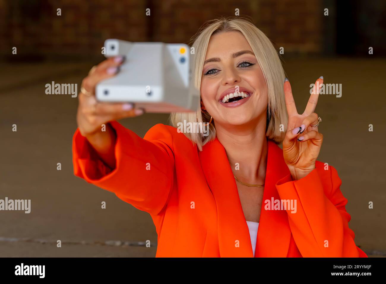 A Lovely Blonde Model Poses Outdoors Using Her Camera While Enjoying ...