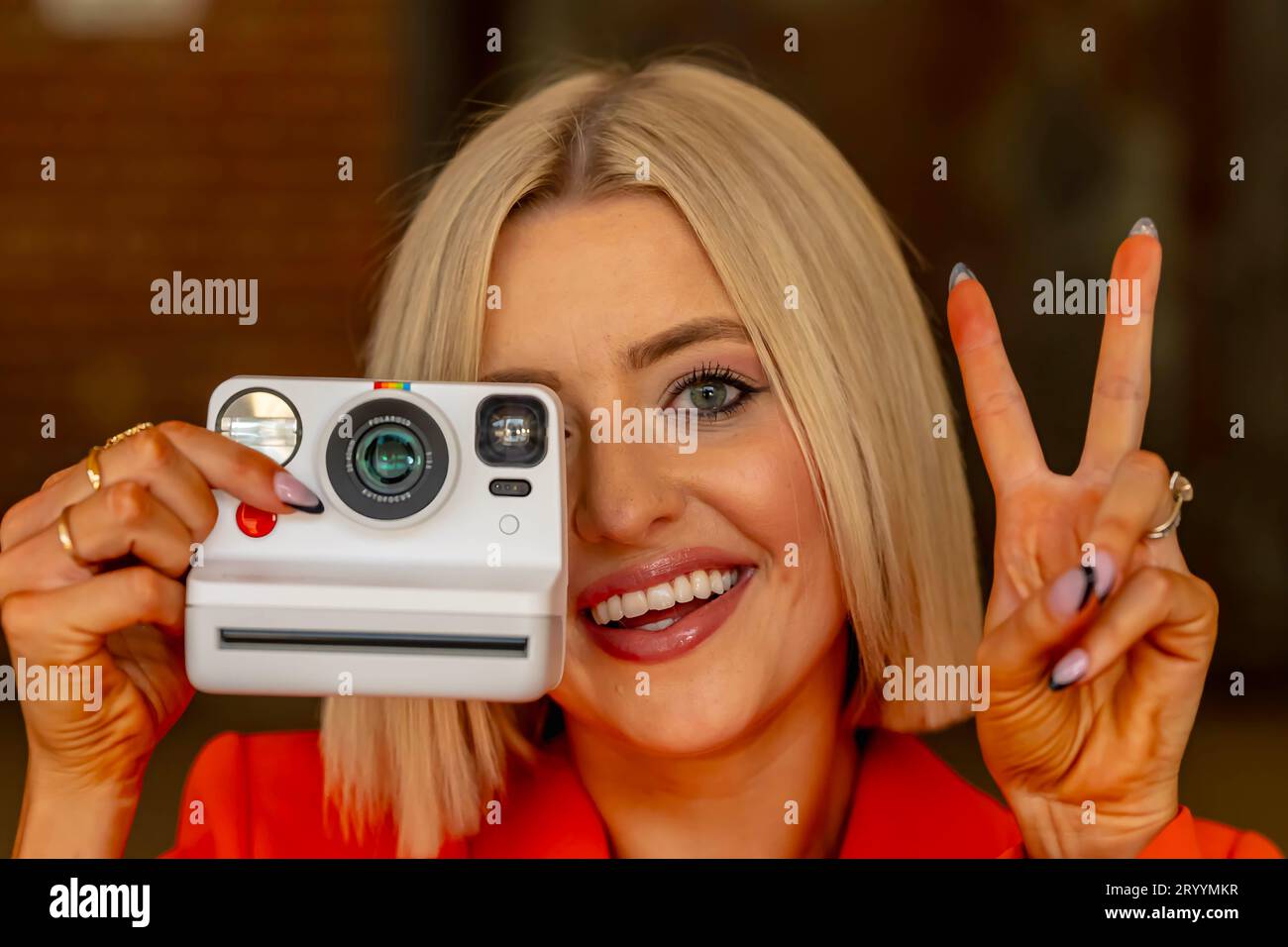 A Lovely Blonde Model Poses Outdoors Using Her Camera While Enjoying ...