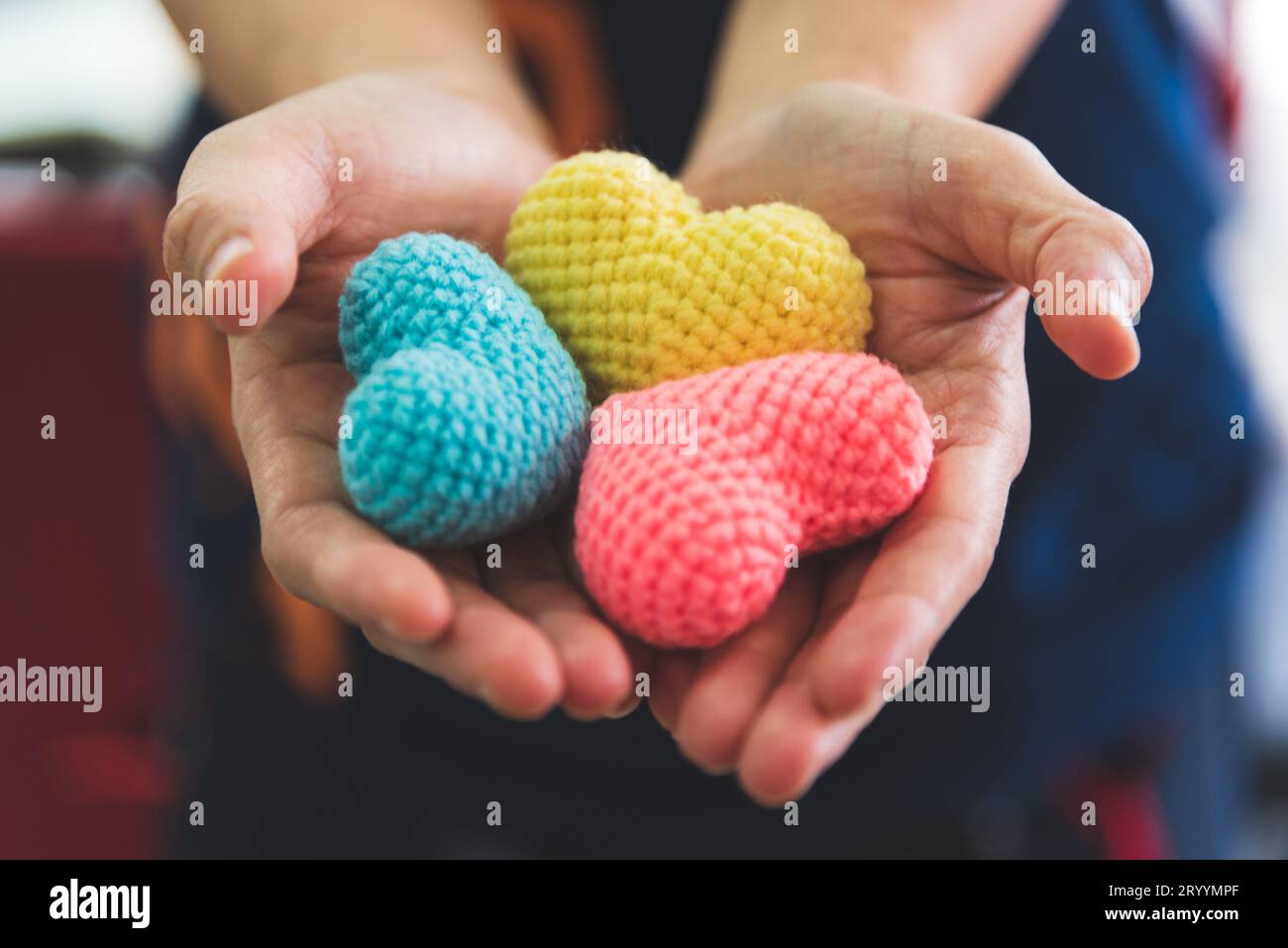 Close up hands giving colorful yarn heart handmade. Valentine day of ...