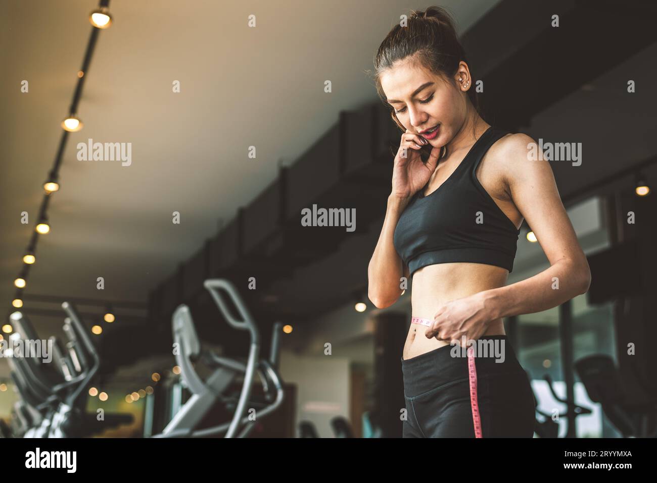 Sport happy slim woman using waist tape line in fitness gym sport club ...