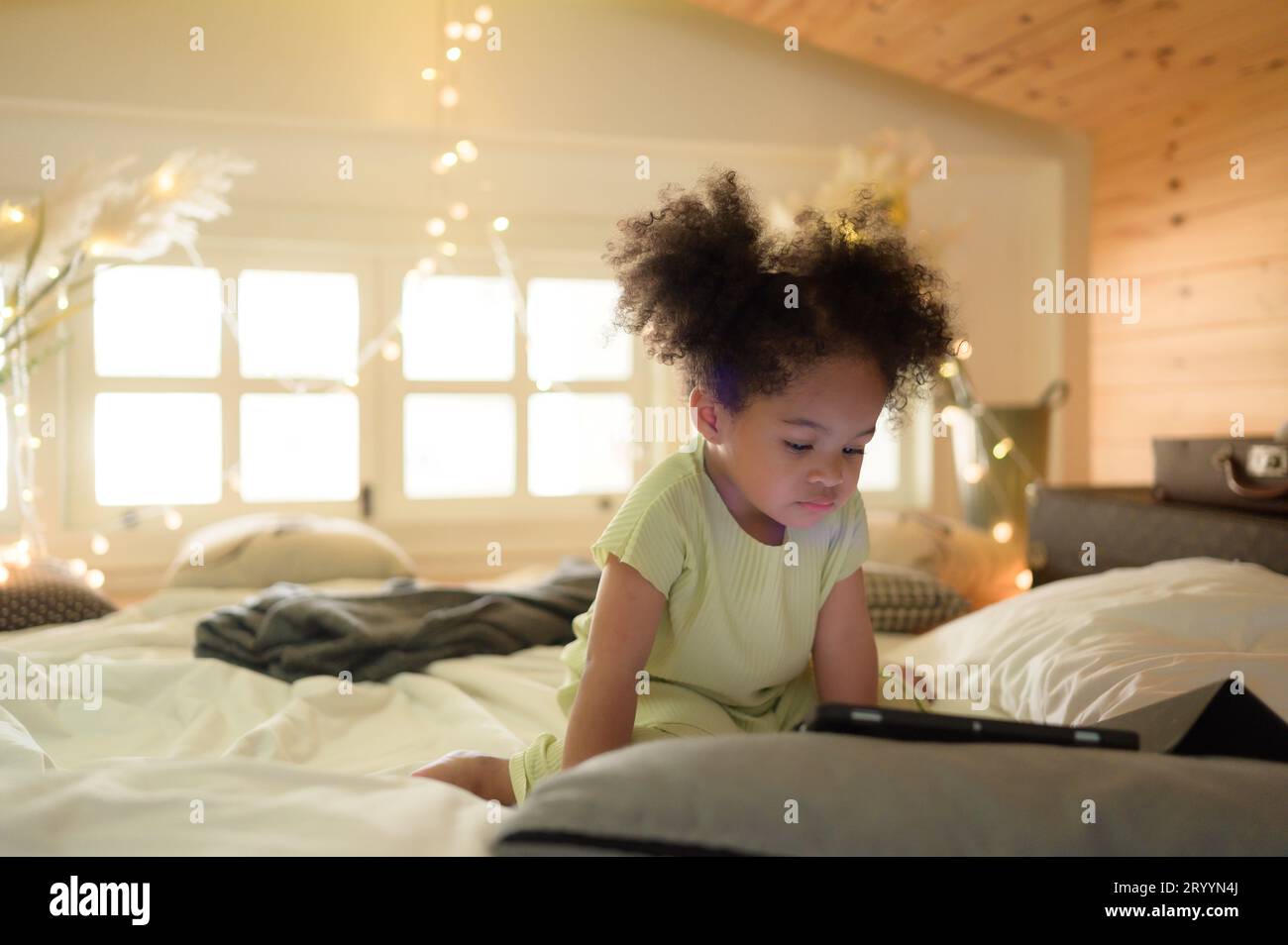 A young bright cute little girl with her trusty tablet that makes her ...