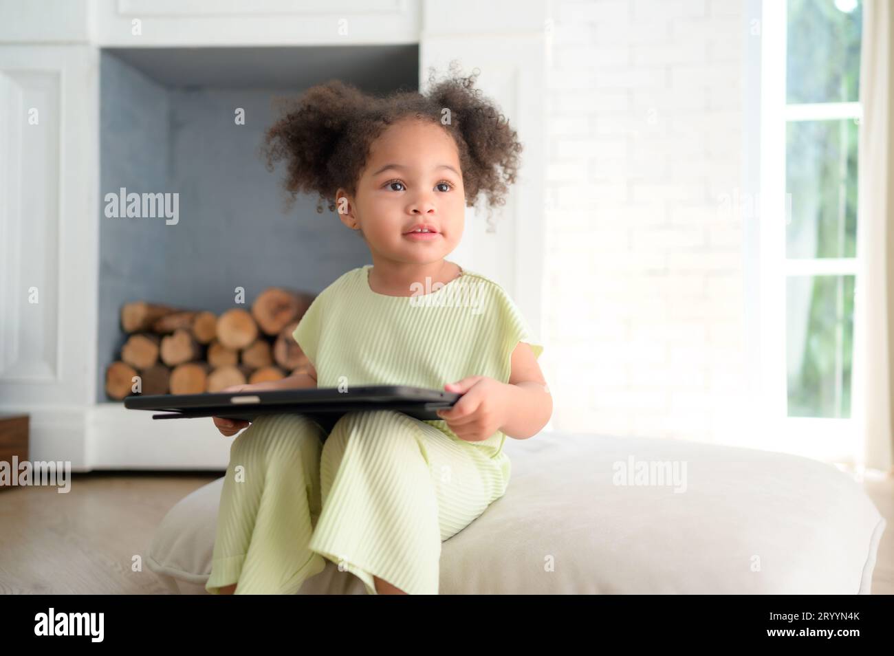 A young bright cute little girl with her trusty tablet that makes her ...