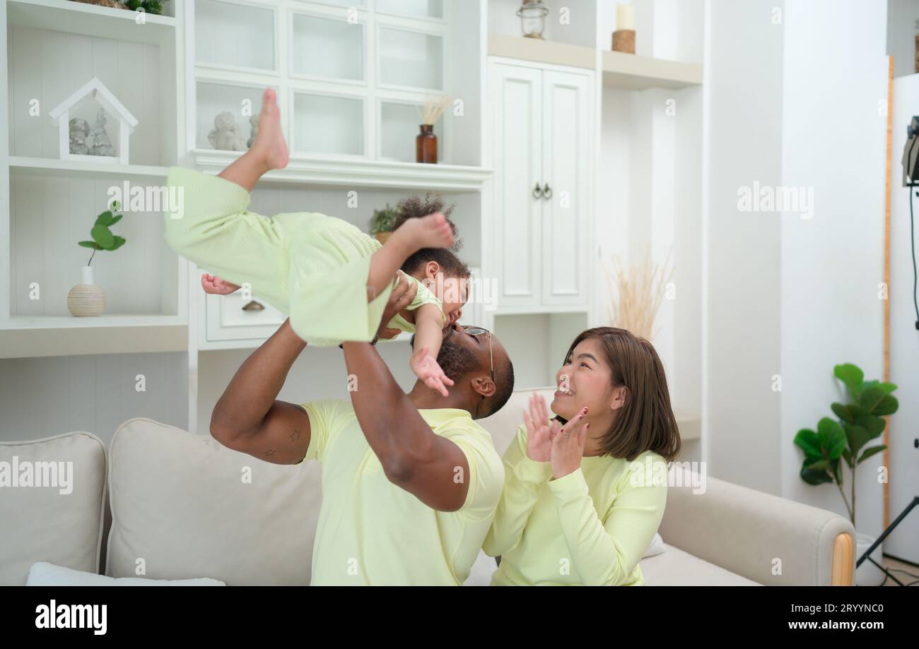 Parent having fun with his daughter by throwing up and lifting her up ...