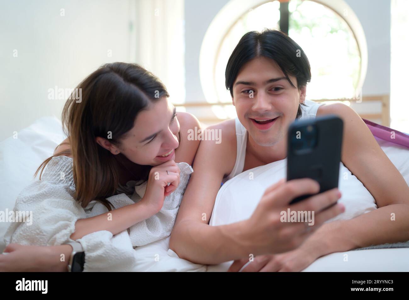 Young couple In the bedroom in the morning, Say hi to pals online using ...