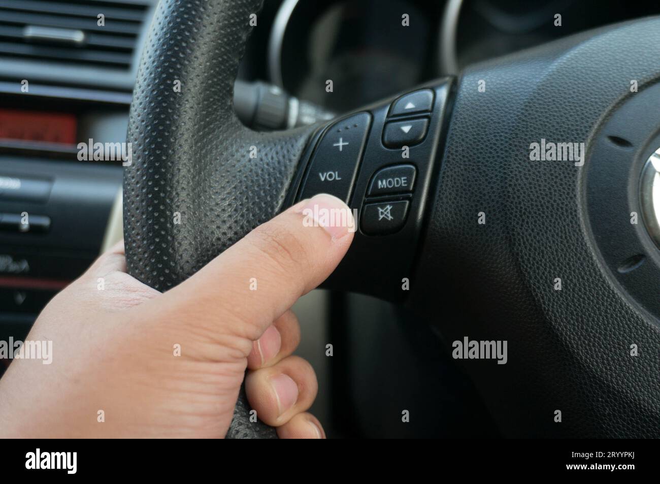 Man driving hands pushing button on the steering wheel in the car ...