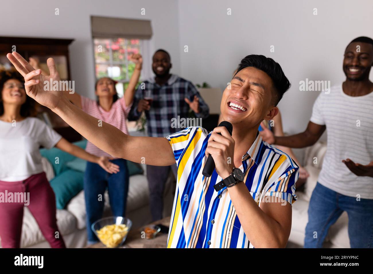Happy diverse friends dancing and karaoke singing with microphone at ...