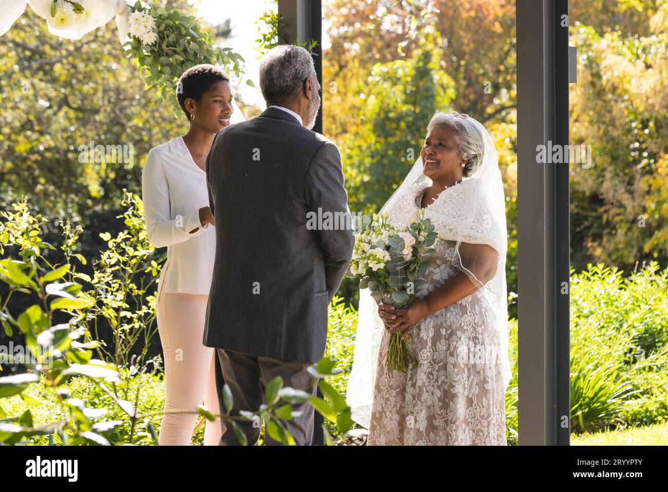 Happy biracial female marriage officiant and senior couple during ...