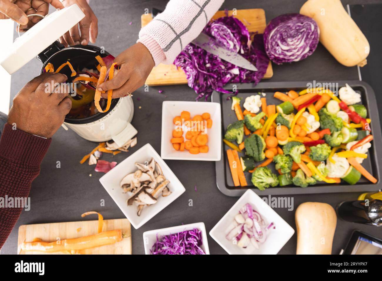 Overhead of senior biracial couple wearing aprons composting food waste ...
