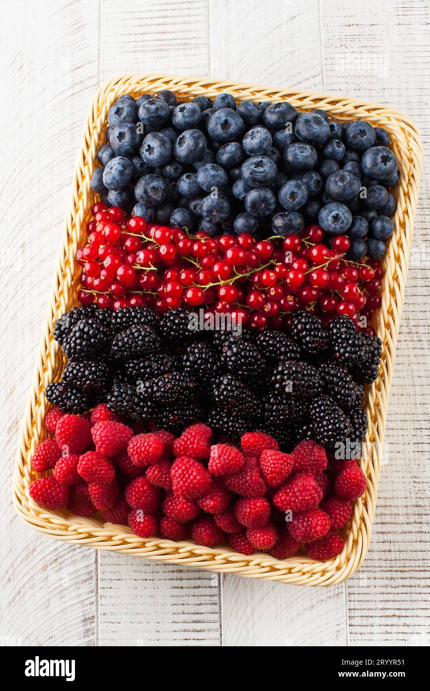 Assorted different types of ripe wild berries in a basket. berries ...