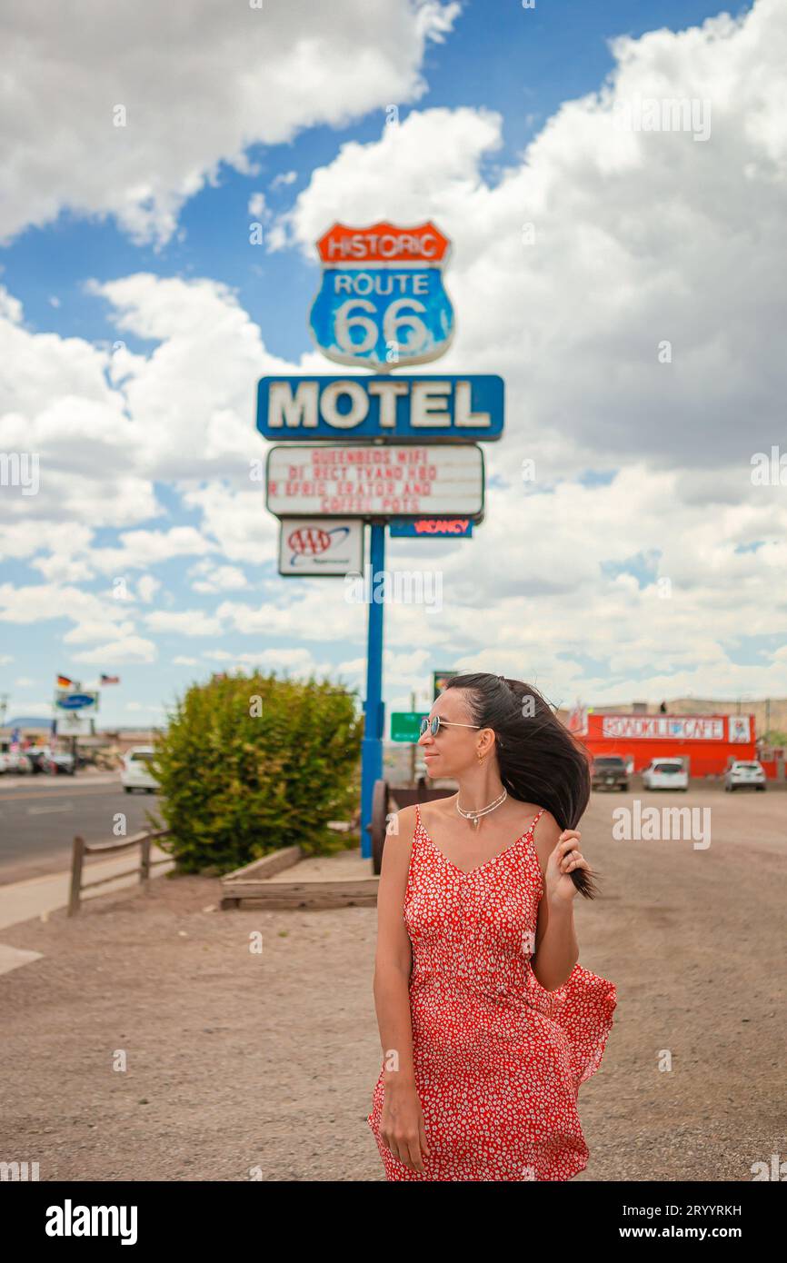 Beautiful woman in red dress on famous Highway under popular sign Route ...