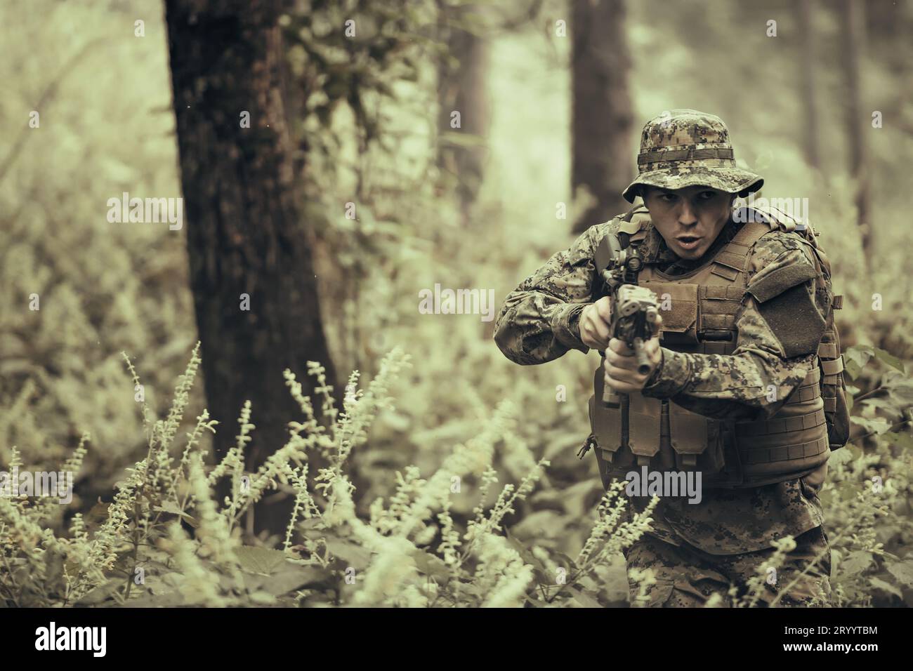 A modern warfare soldier on war duty in dense and dangerous forest areas. Dangerous military ...