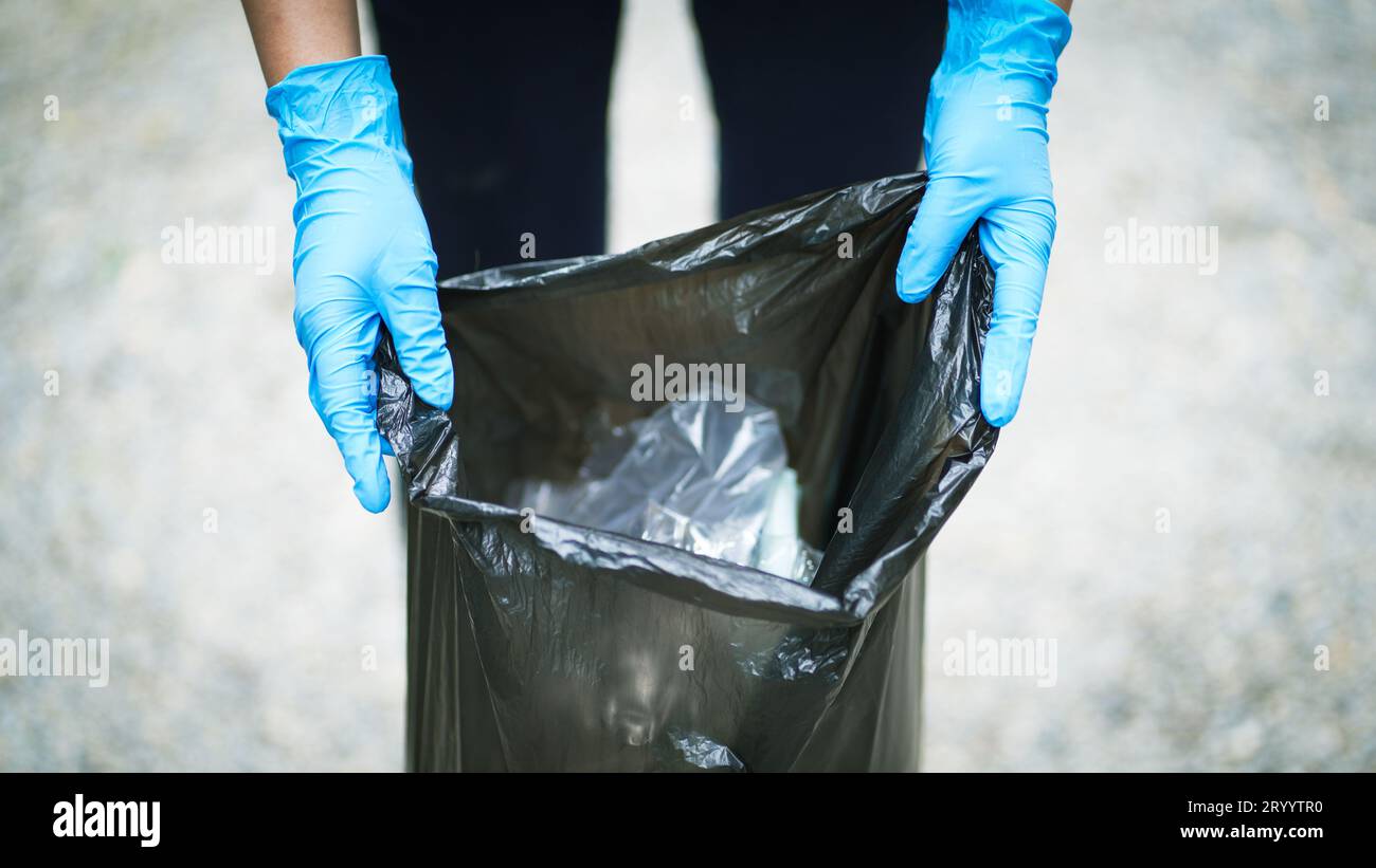 Volunteer charity womanÂ hand holding garbage black bag and plastic ...