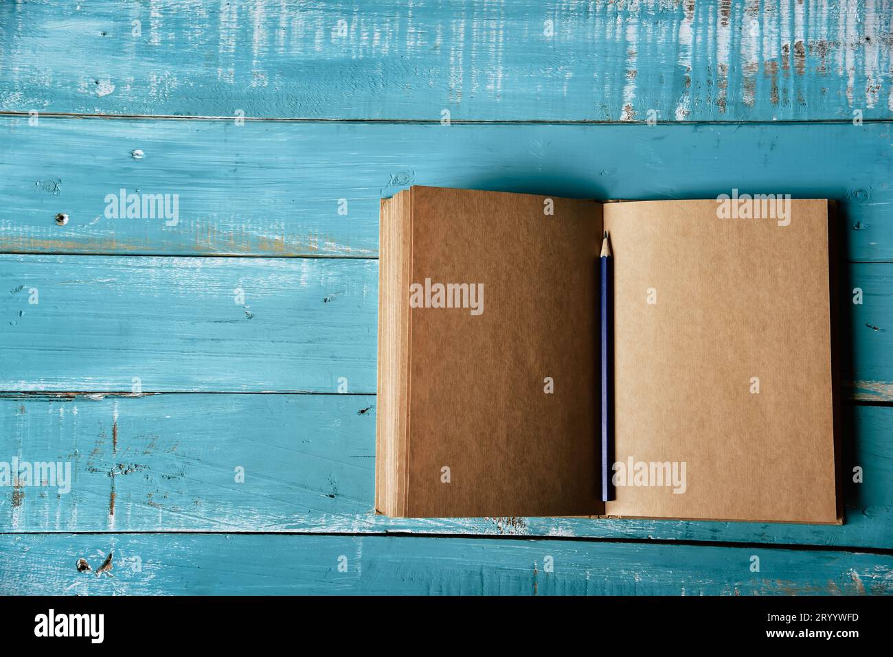 Top view of blank open notebook on blue wooden background with purple ...