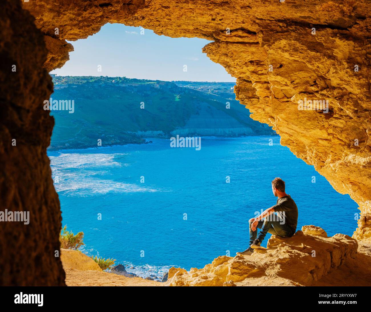 Gozo island Malta, young man and a View of Ramla Bay, from inside Tal ...