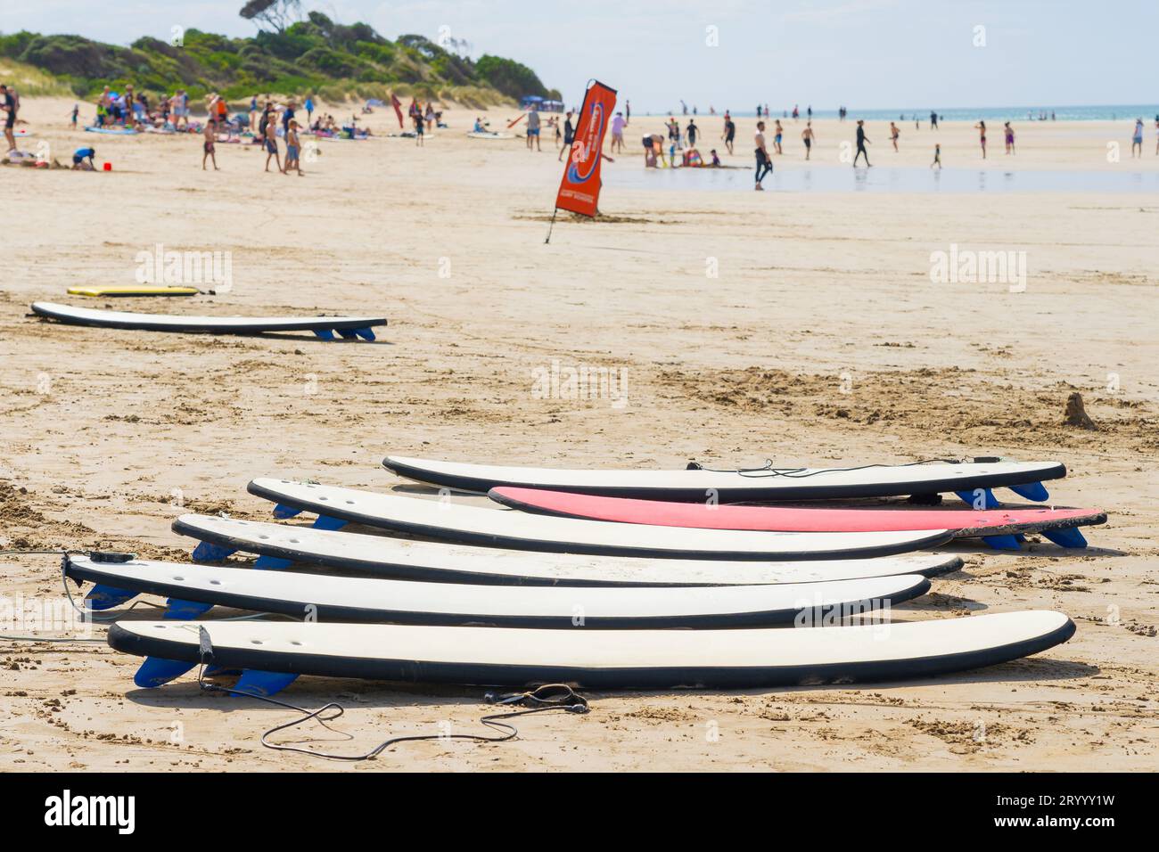 A row of surfboards on a crowded beach along the Great Ocean Road at ...