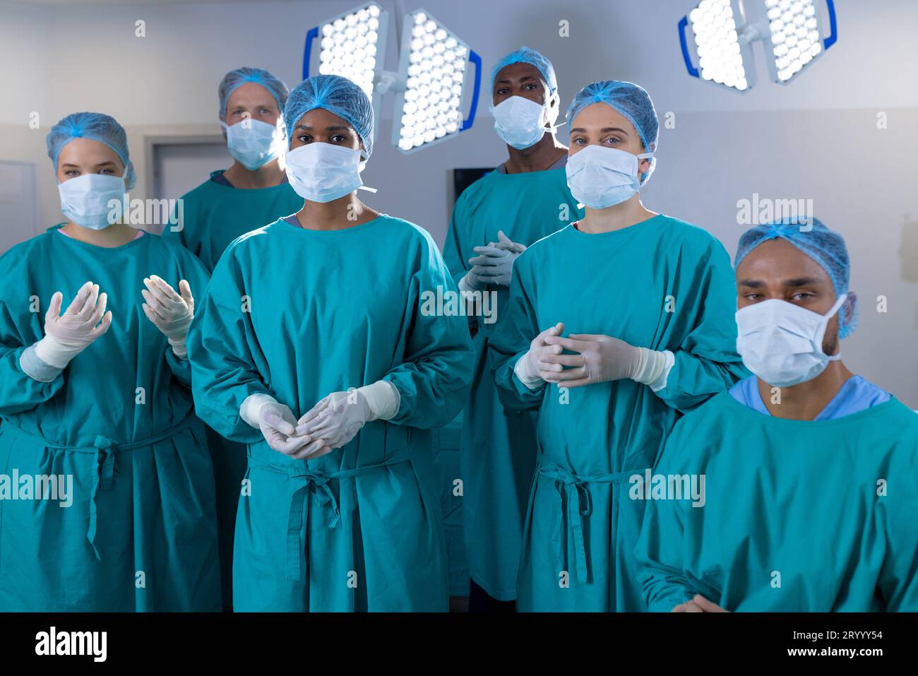 Portrait of diverse surgeons wearing surgical gowns in operating ...