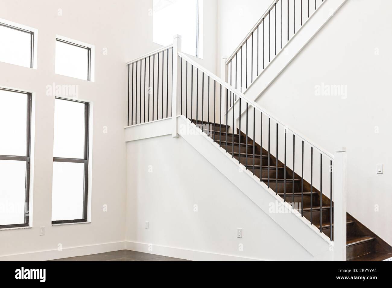 Modern white wooden staircase in new house interior with big windows ...