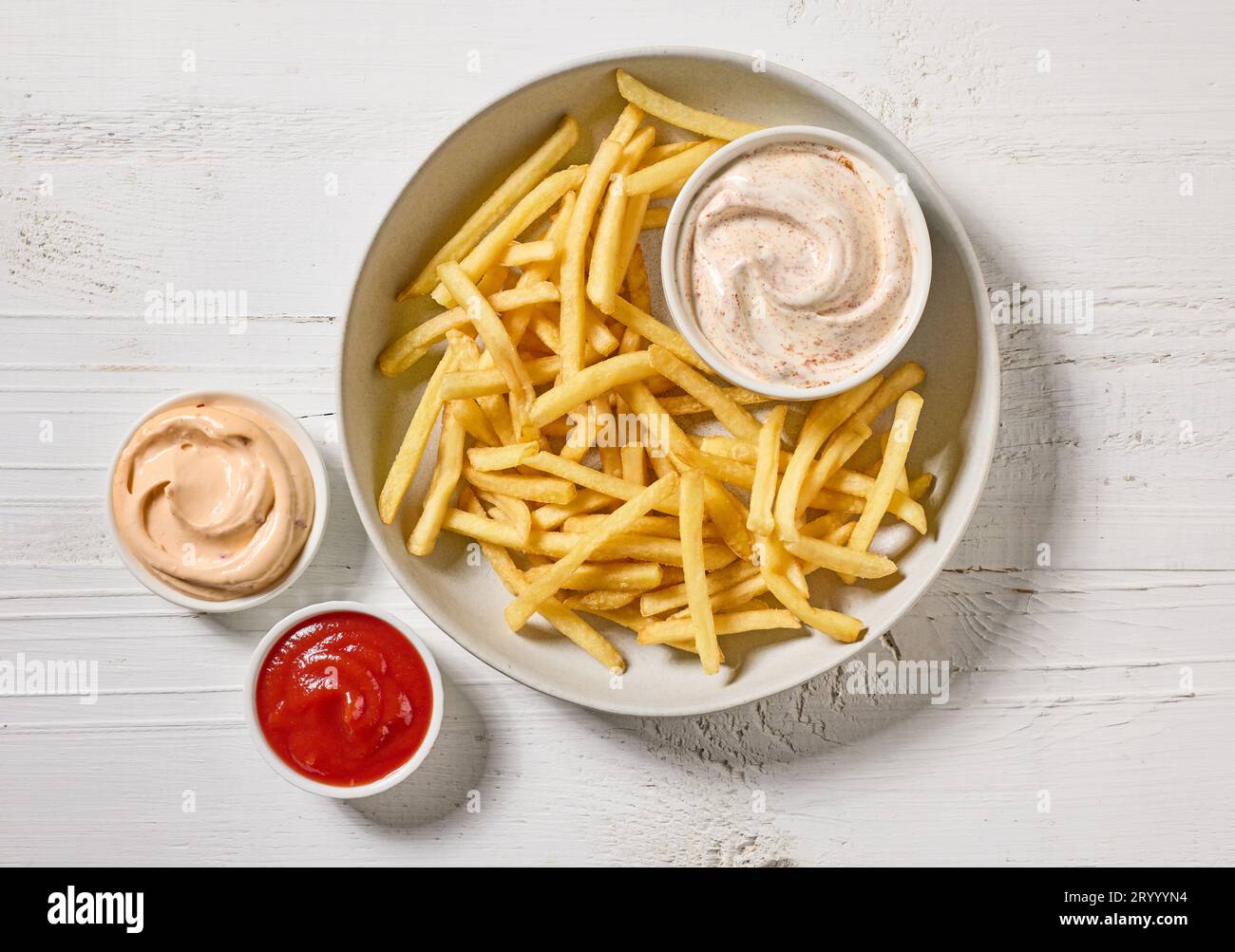 french fries with various dip sauces on white wooden table, top view ...