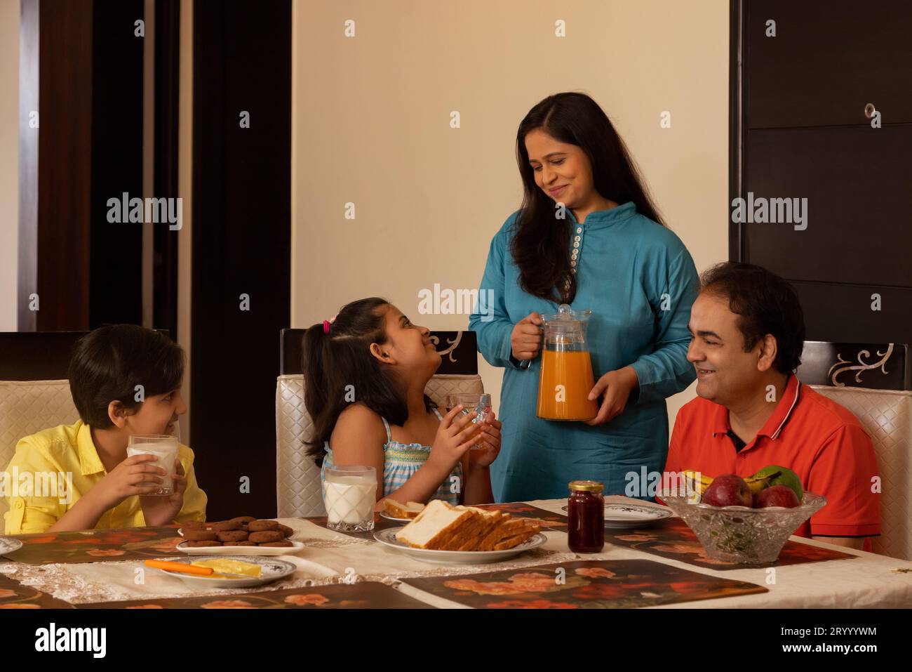 Portrait of happy middle class family together at home during breakfast ...