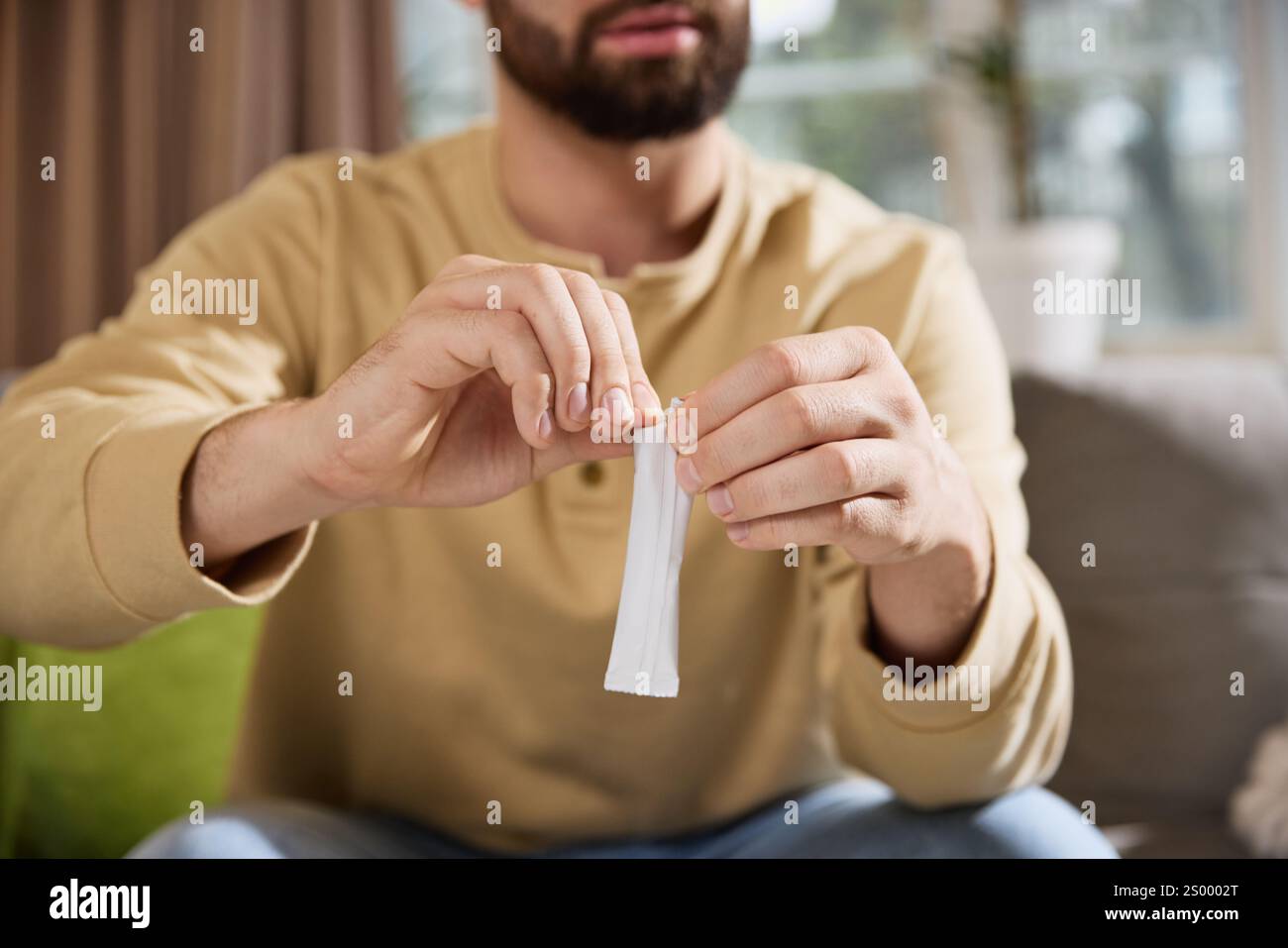 Close-up photo of young man open sachet package with negative space to ...