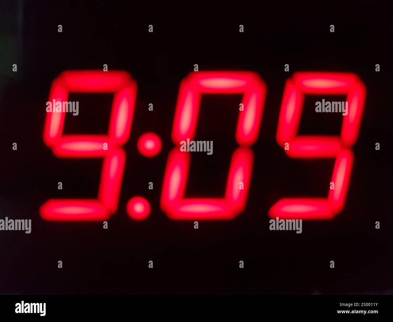 A digital clock face showing the time in red numbers on a black ...