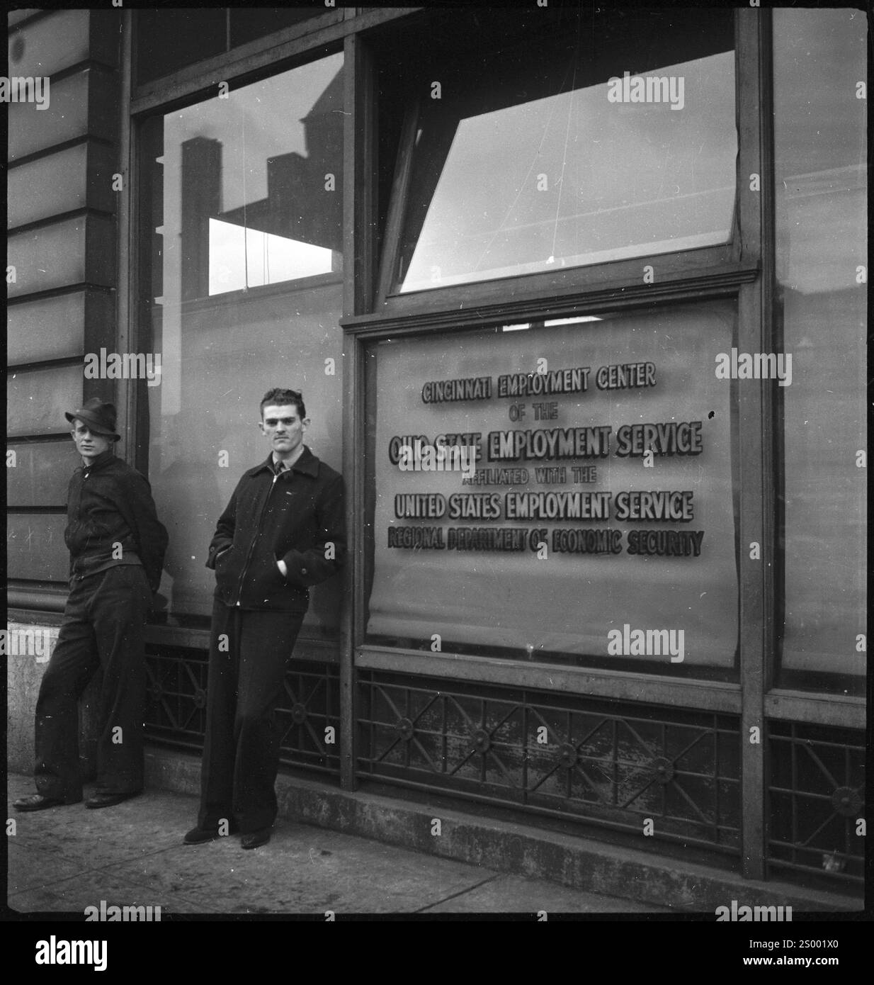 Cincinnati, Ohio, USA. circa 1937 People; Two men lean against a house ...
