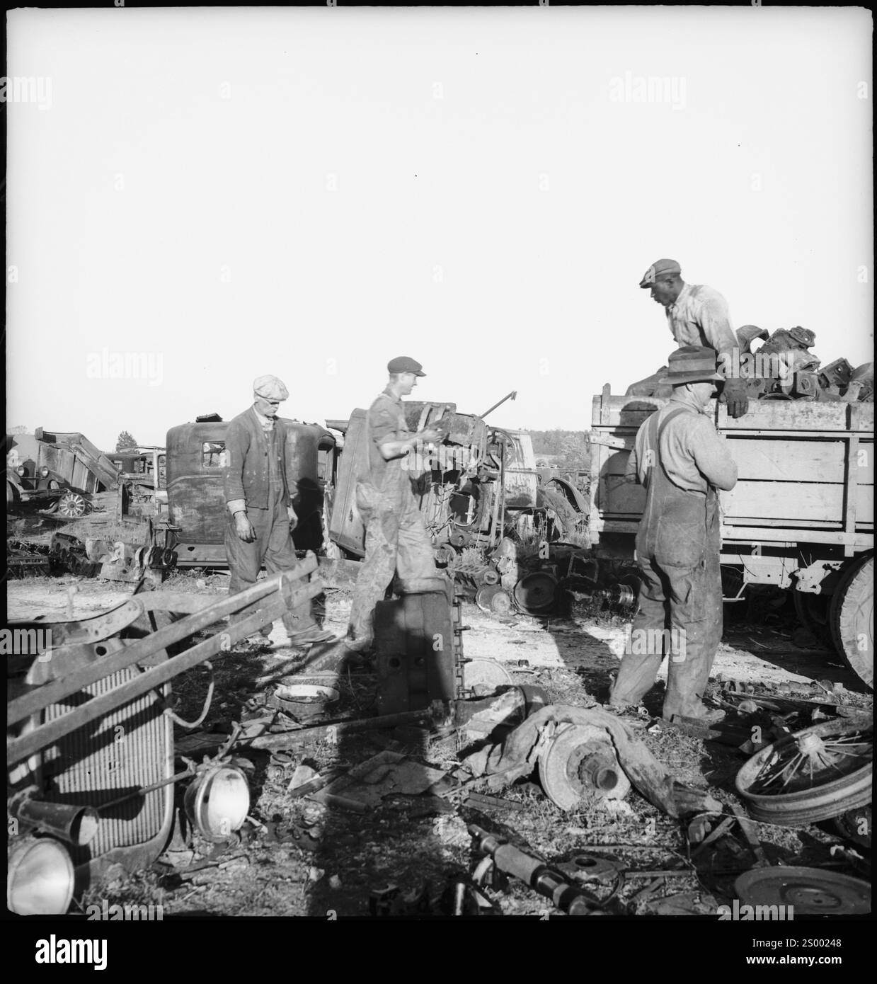 Athens, Tennessee, USA. 1938. Car cemetery; men unloading a truck, car ...