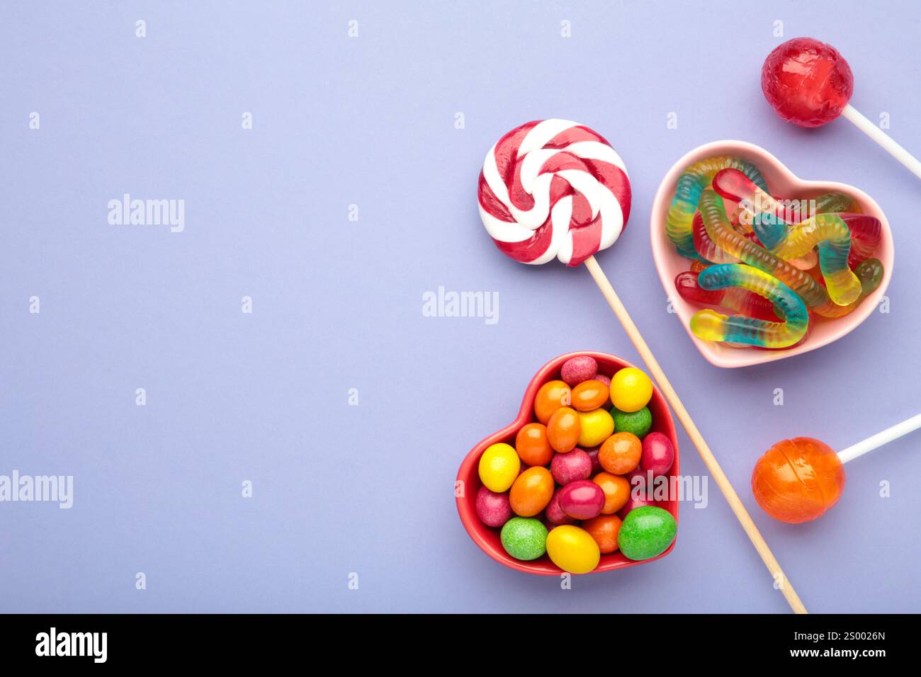 Different types of candies on purple background, copy space. Colorful ...