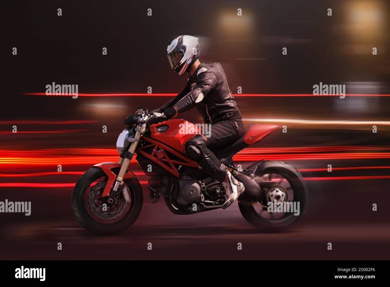 Motorcycle rider in helmet and gear racing at high speed in red colors ...