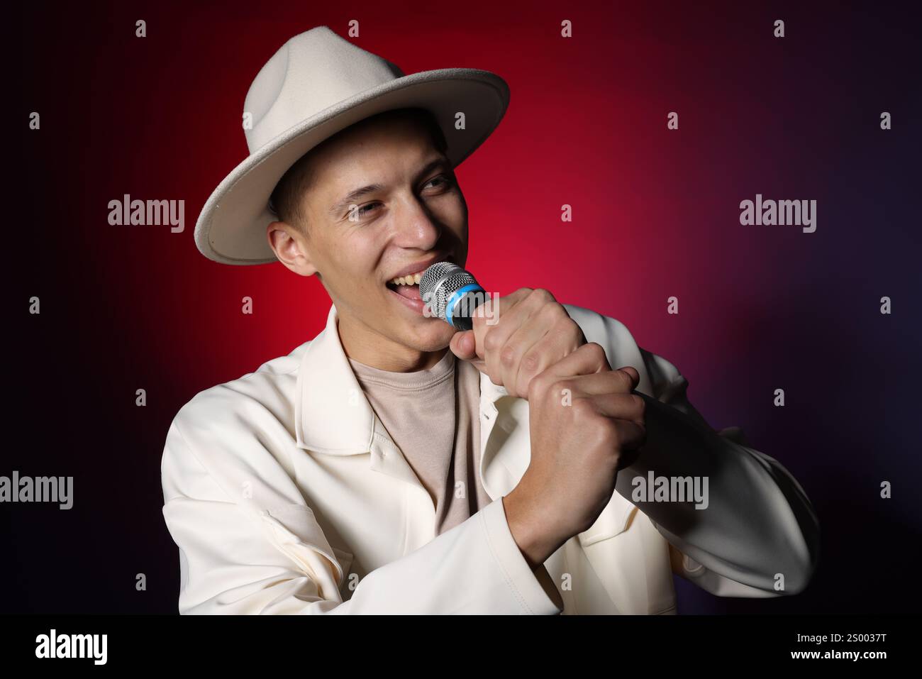 Talented young man singing on dark background with red light Stock ...