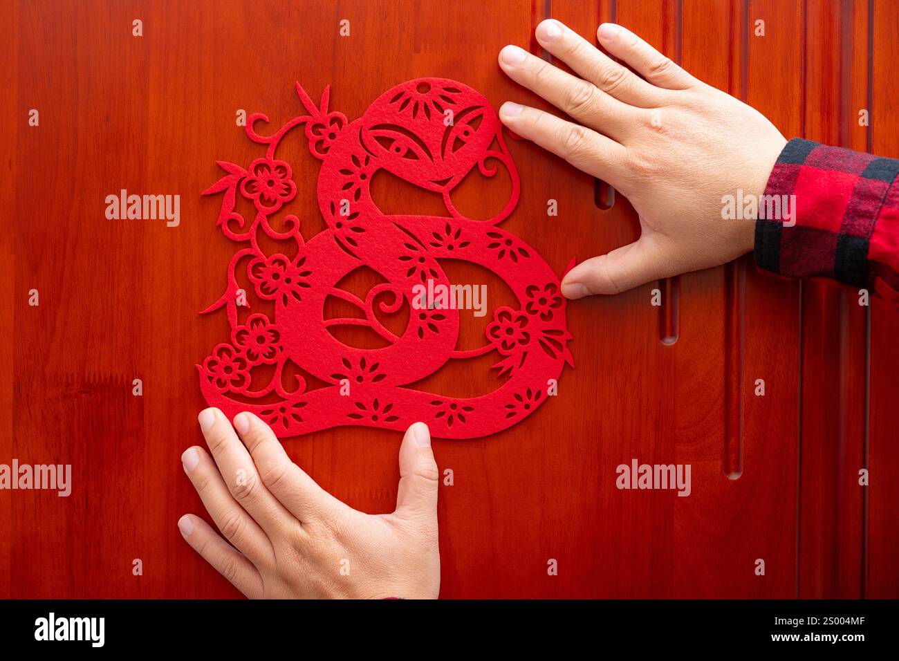 man sticking a Chinese New Year of the Snake decoration to a door Stock ...