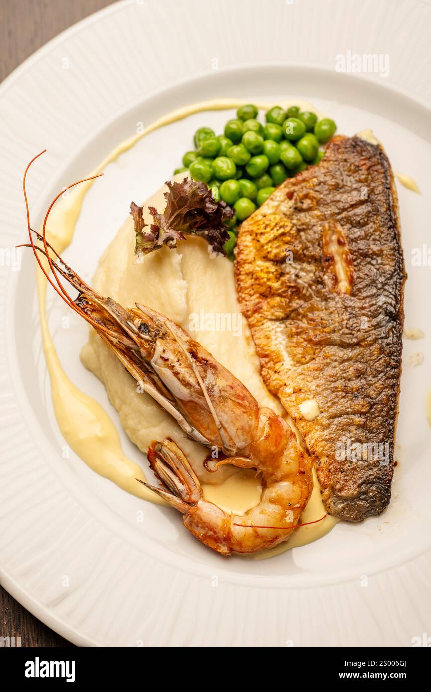 Fish and prawn with mash potatoes and pea dish Stock Photo - Alamy