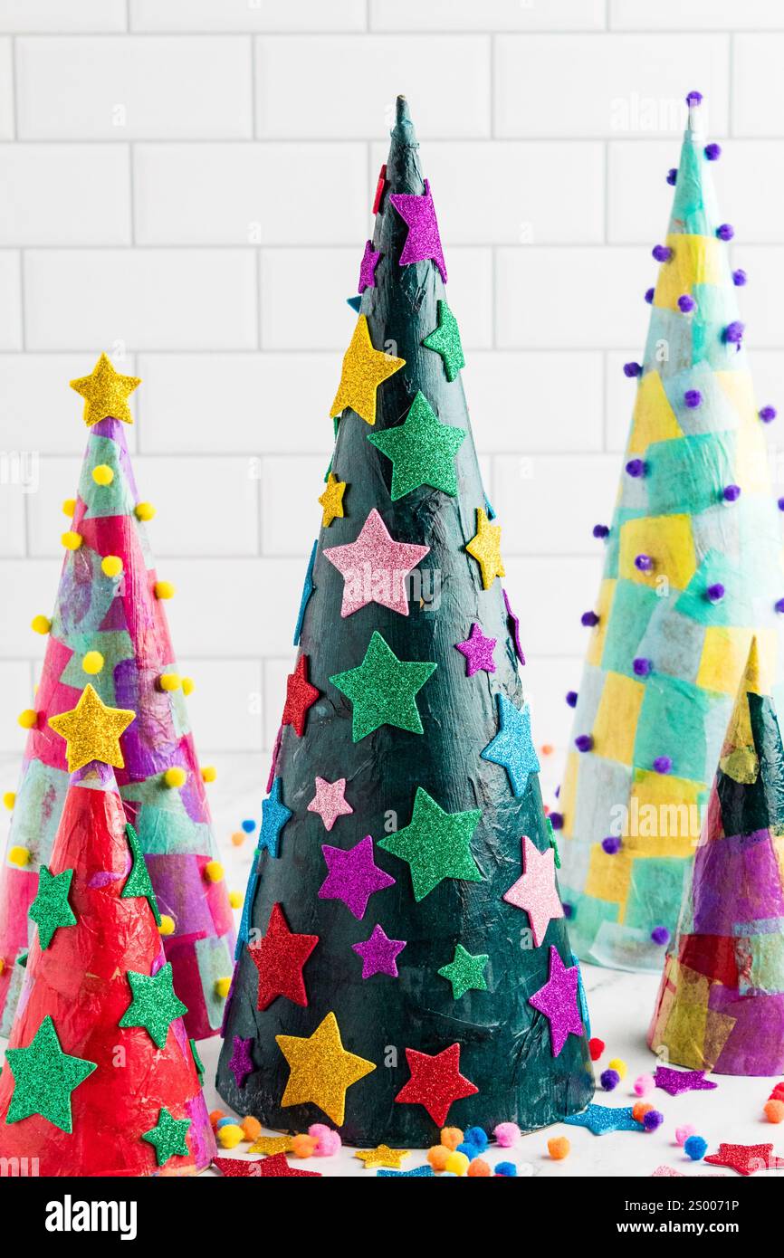 Tissue paper cone trees decorated with stars and pom-poms Stock Photo ...