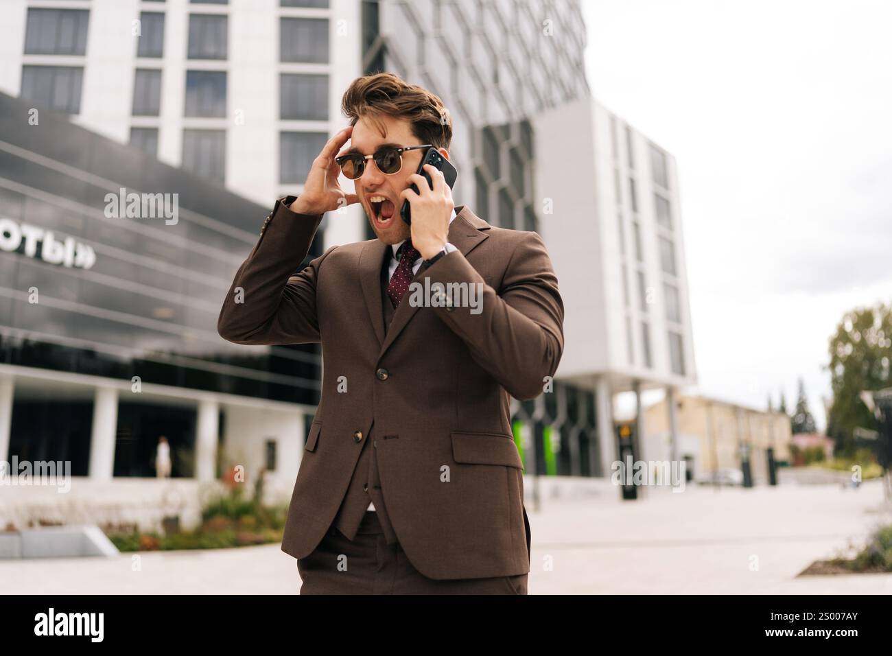 Angry young businessman in suit and sunglasses experiencing extreme ...