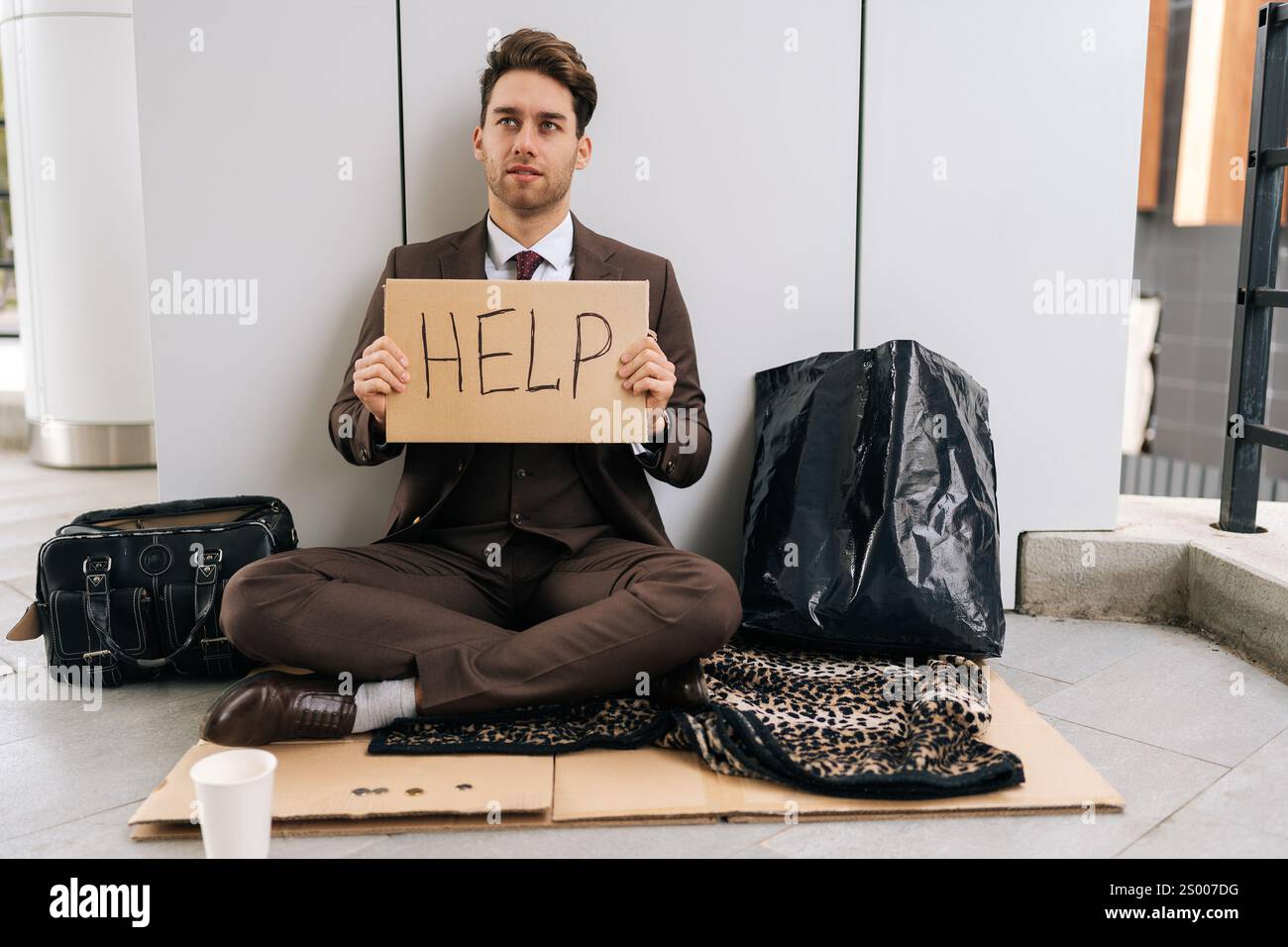 Portrait of sad homeless millennial businessman wearing suit and tie ...