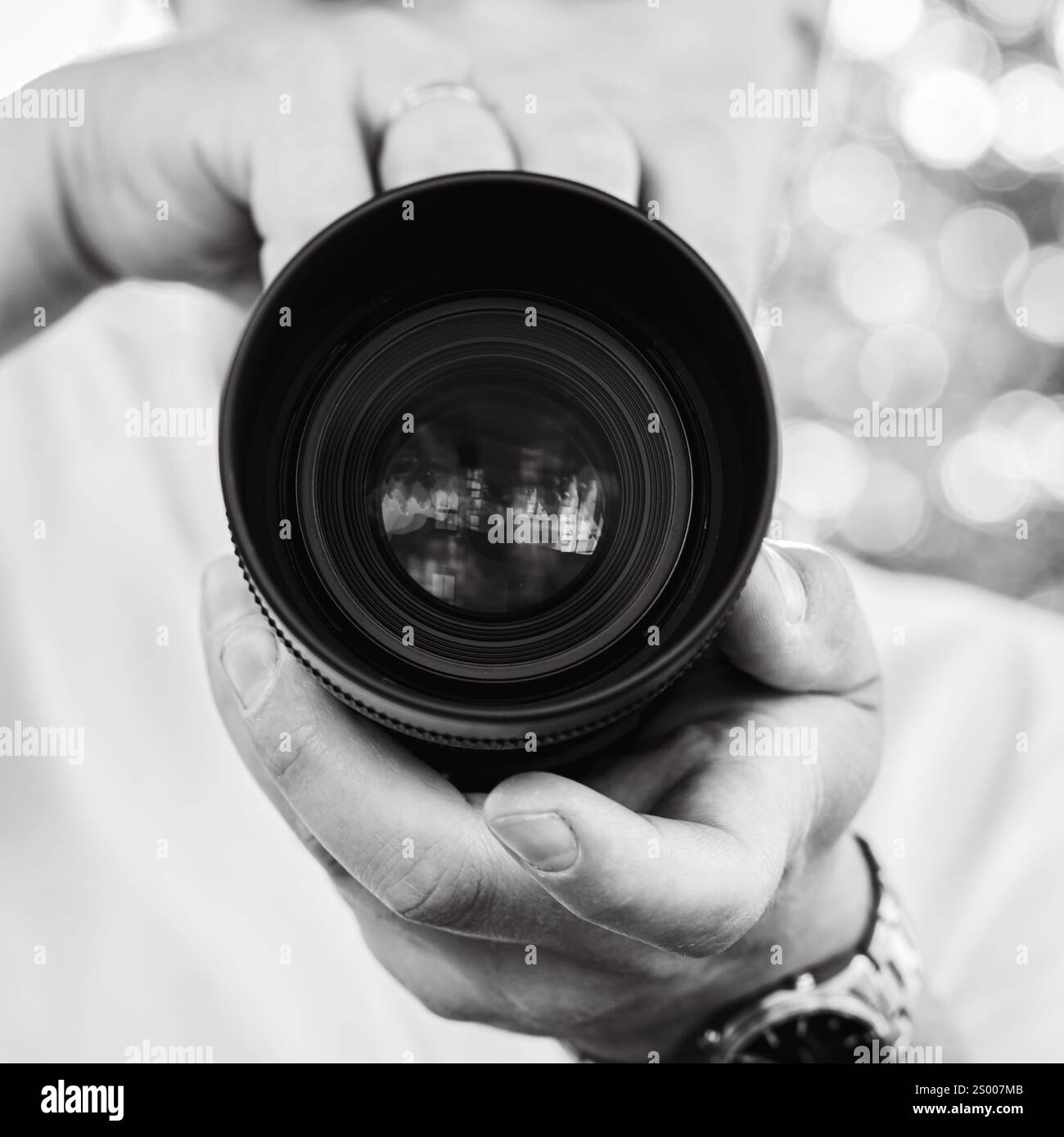 Camera with lens in photographer's hands Stock Photo - Alamy
