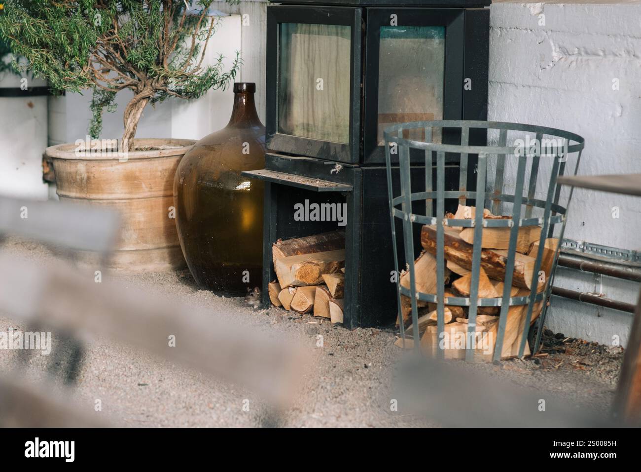 rat peering out from the side of a log burning stove in a house Stock ...