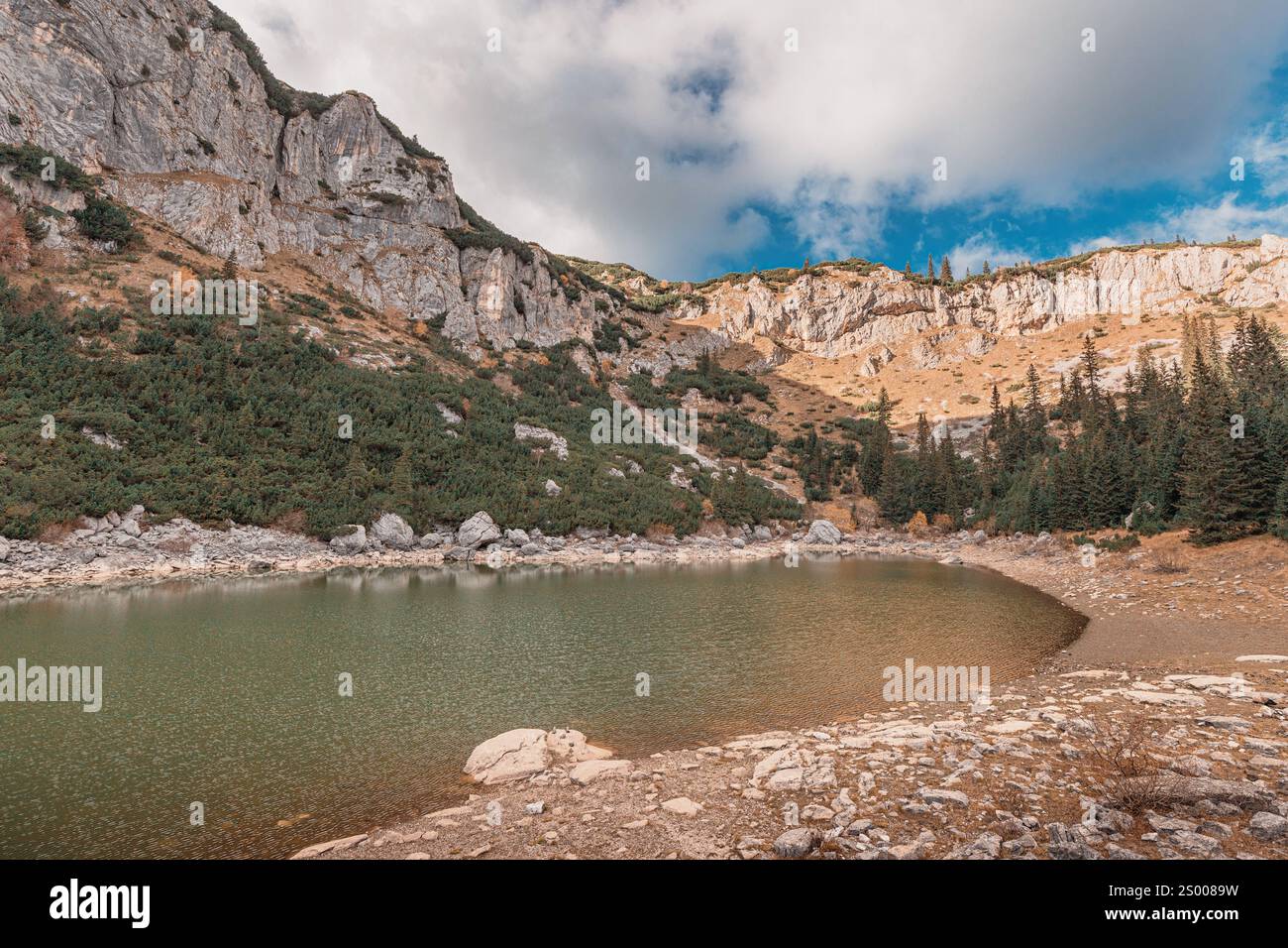 Calm mountain lake Jablan reflecting surrounding landscape under cloudy ...
