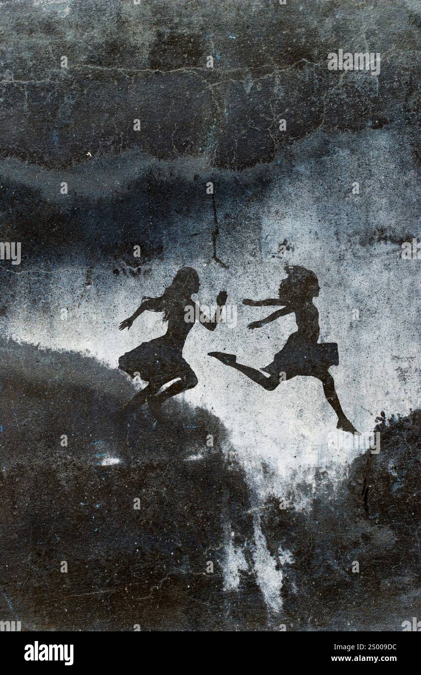 Two women leaping a chasm Stock Photo - Alamy