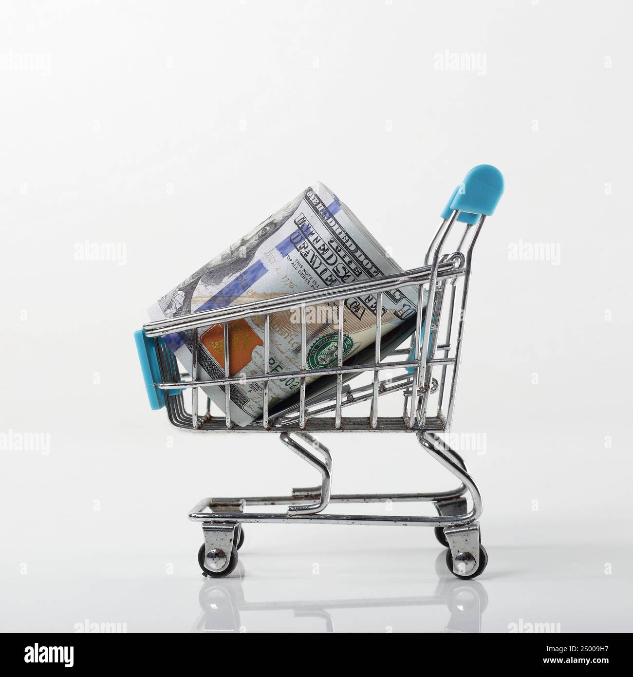 A stack of rolled up US hundred dollar bills in a shopping cart on a ...