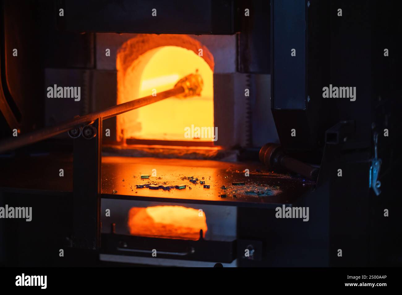 Molten glass on a blowpipe inside of open furnace, glass blowing ...