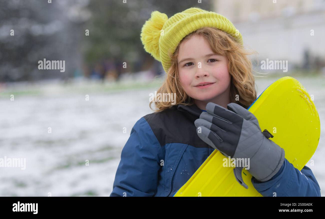 Winter Kids face. Kid play with Winter snowboard. First Winter snow ...