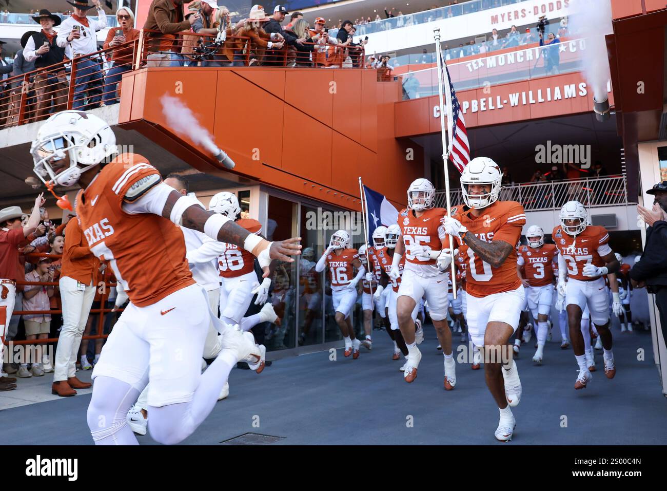 AUSTIN, TX - DECEMBER 21: Texas Longhorns players run onto the field with the US and Texas flags ...
