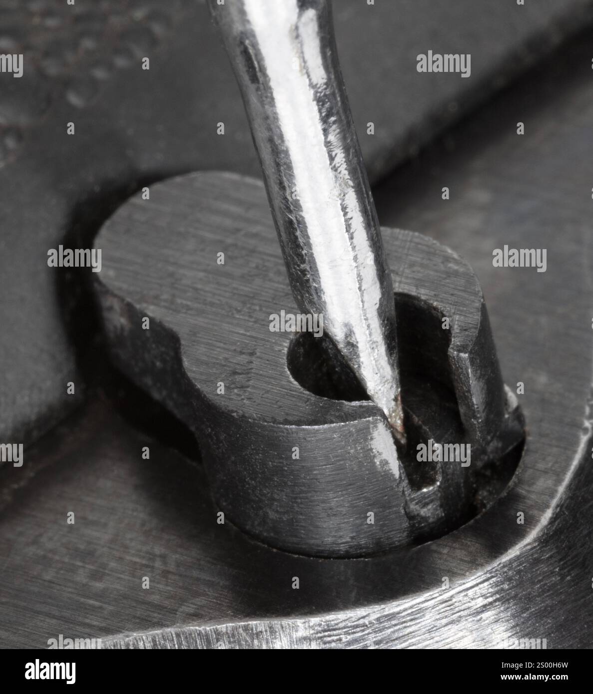 Magazine spring catch on a semi-auto pistol being turned to remove and ...