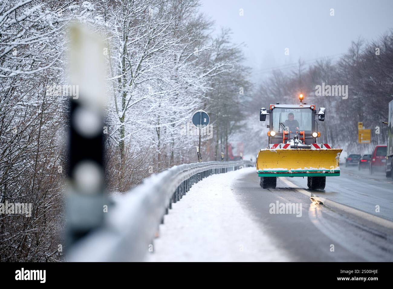 Winterberg, Germany. 23rd Dec, 2024. A snow plow drives over a road ...